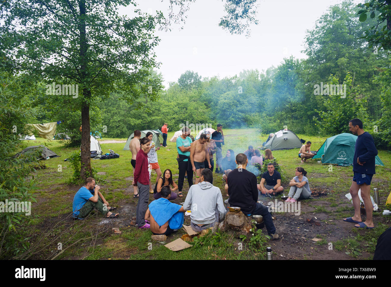 group of tourists around the campfire, Hiking and camping of young ...