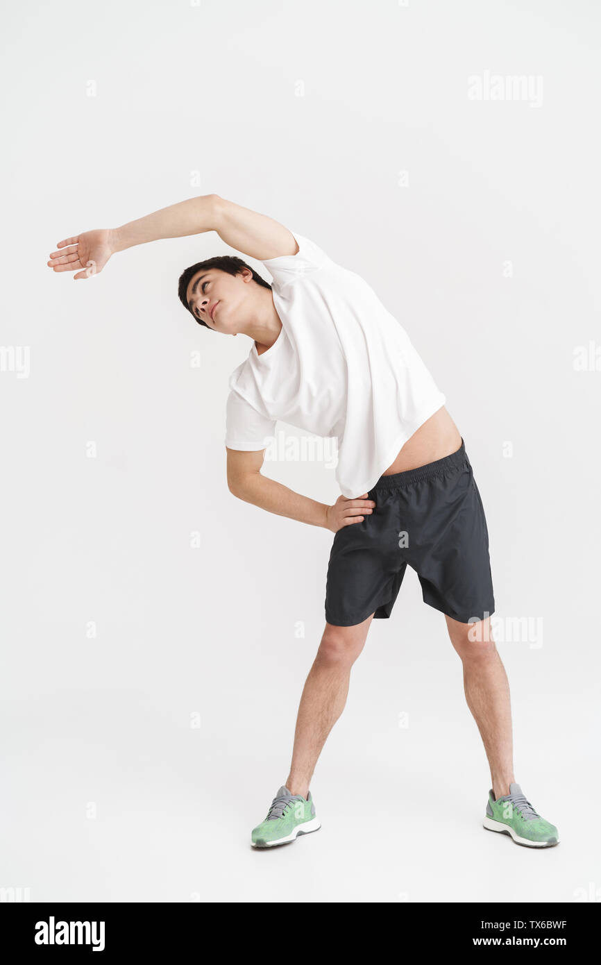 Full length portrait of a healthy fit young sportsman warming up before ...