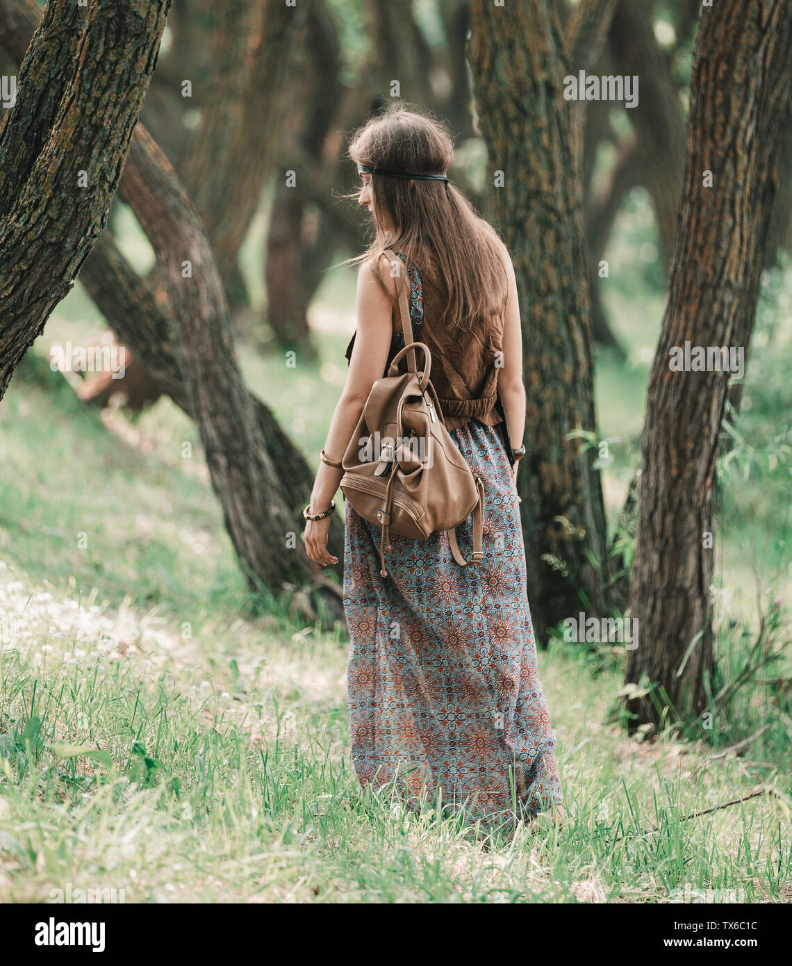 attractive hippie girl walking through the forest . the concept of ...