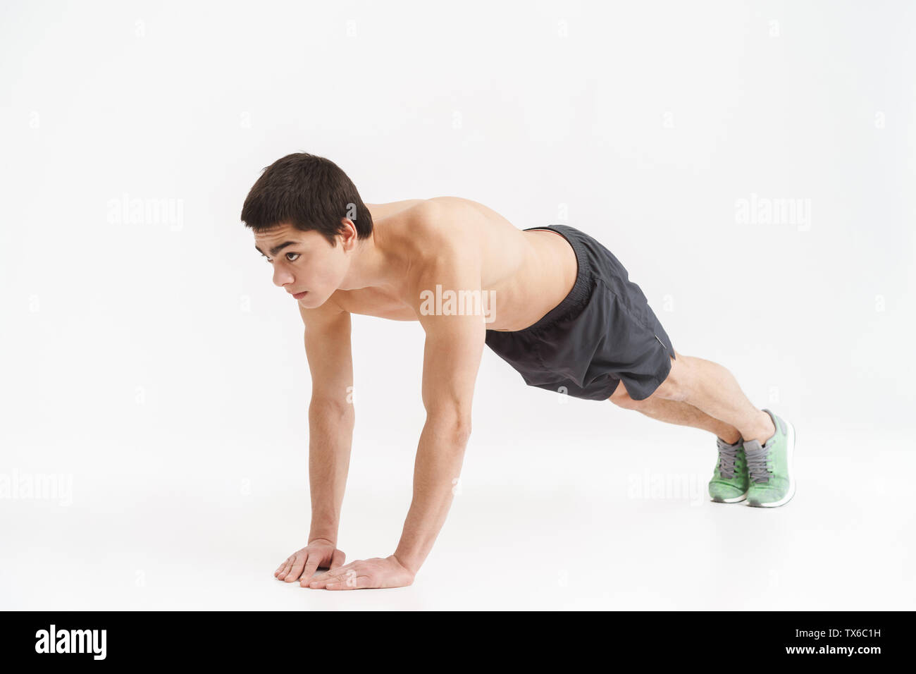 Full length of a healthy fit sportsman doing plank exercises isolated ...