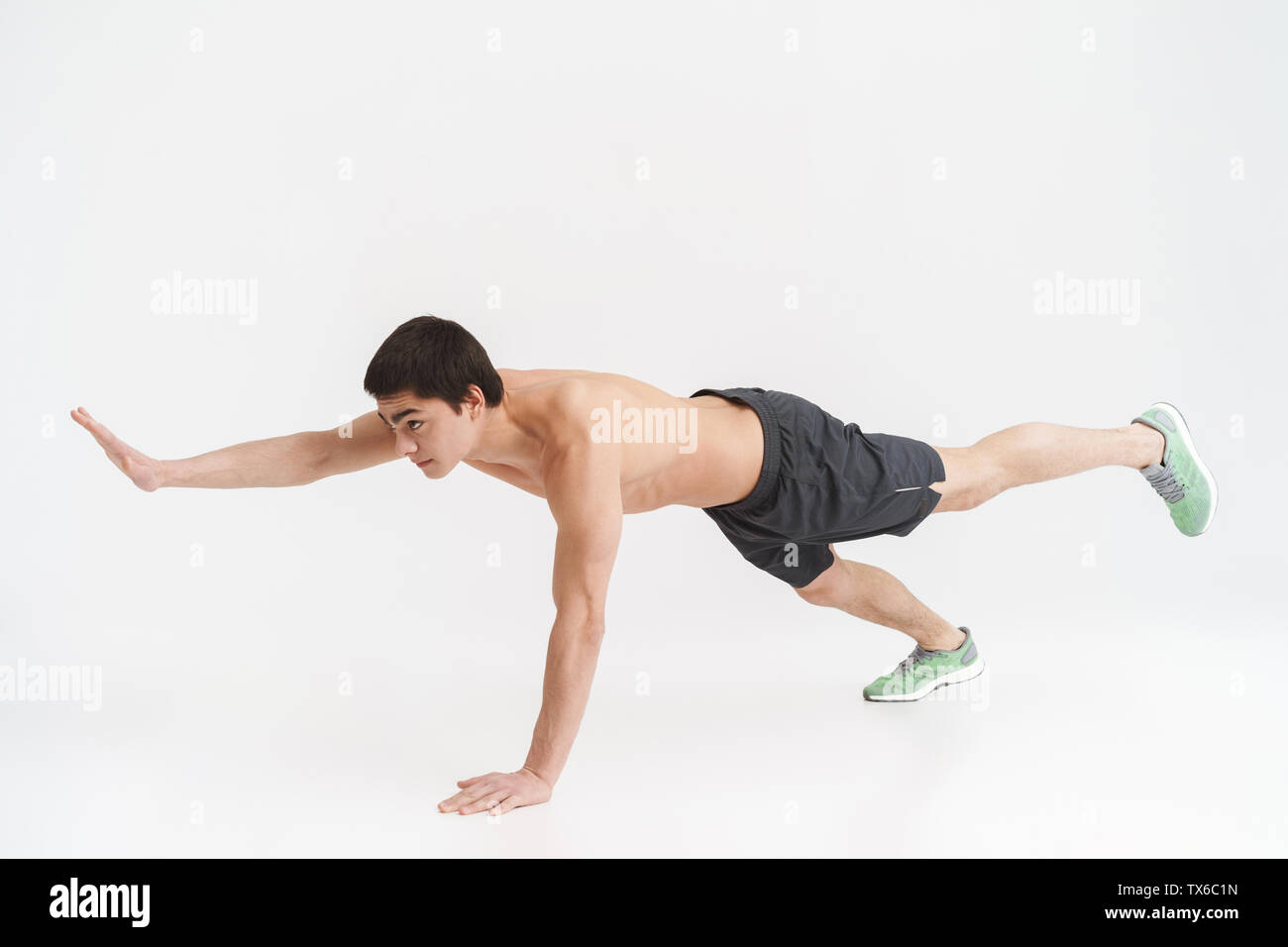 Full length of a healthy fit sportsman doing plank exercises isolated ...