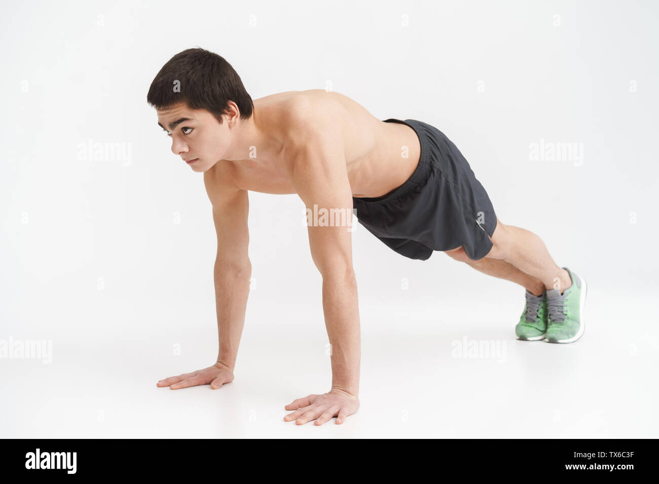 Full length of a healthy fit sportsman doing plank exercises isolated ...