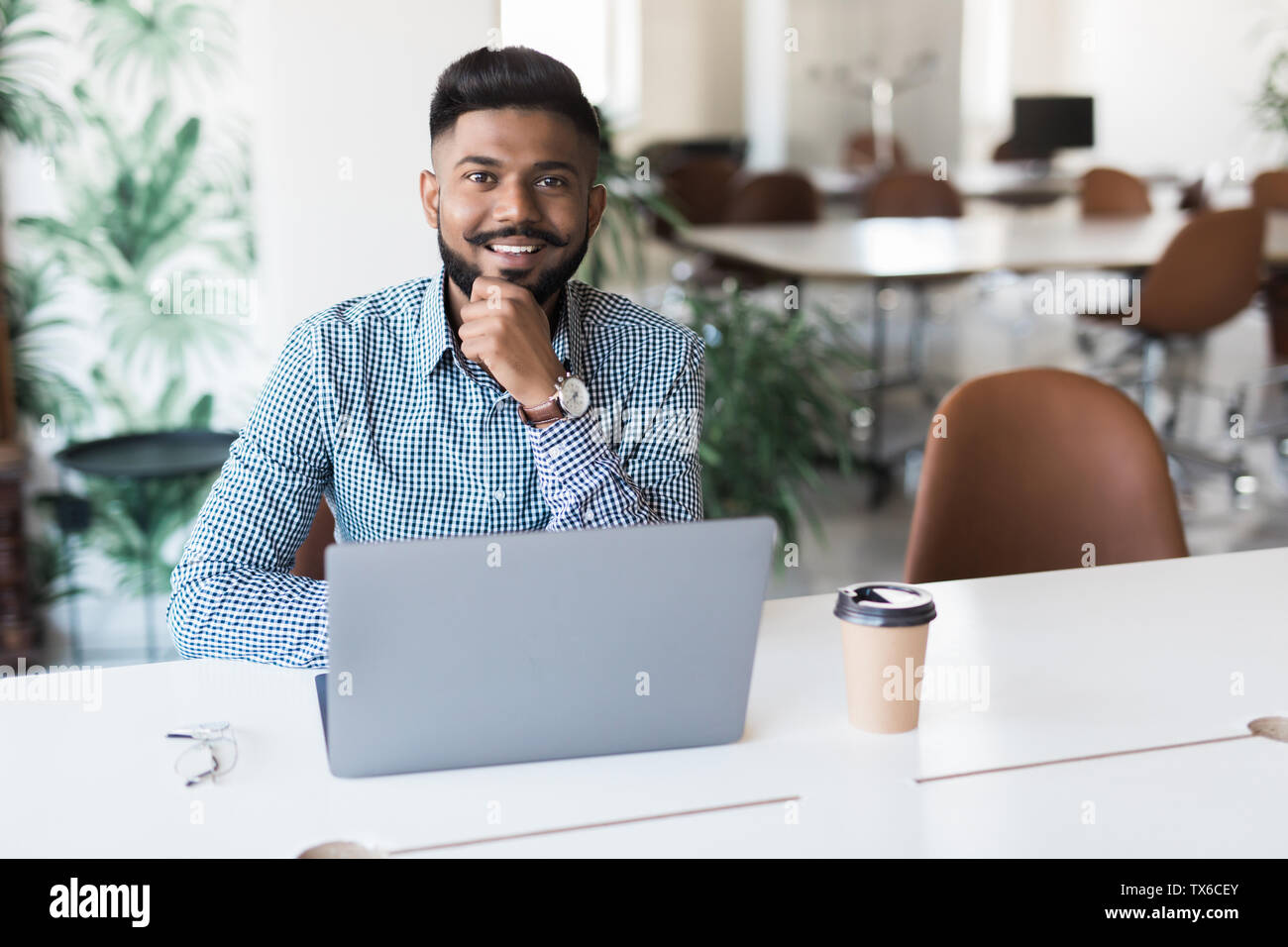 casual indian man smiling and working at office Stock Photo - Alamy