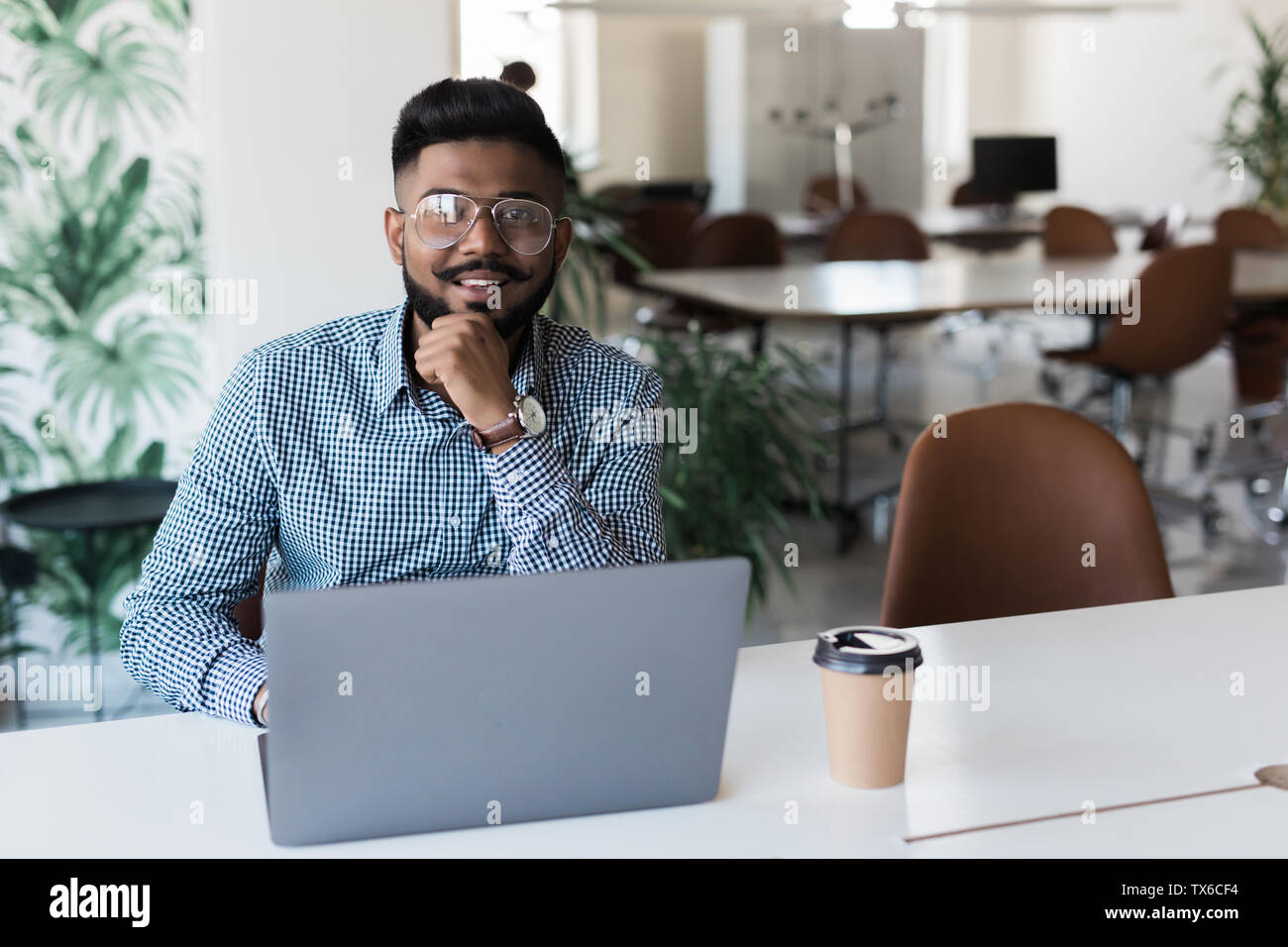 casual indian man smiling and working at office Stock Photo - Alamy