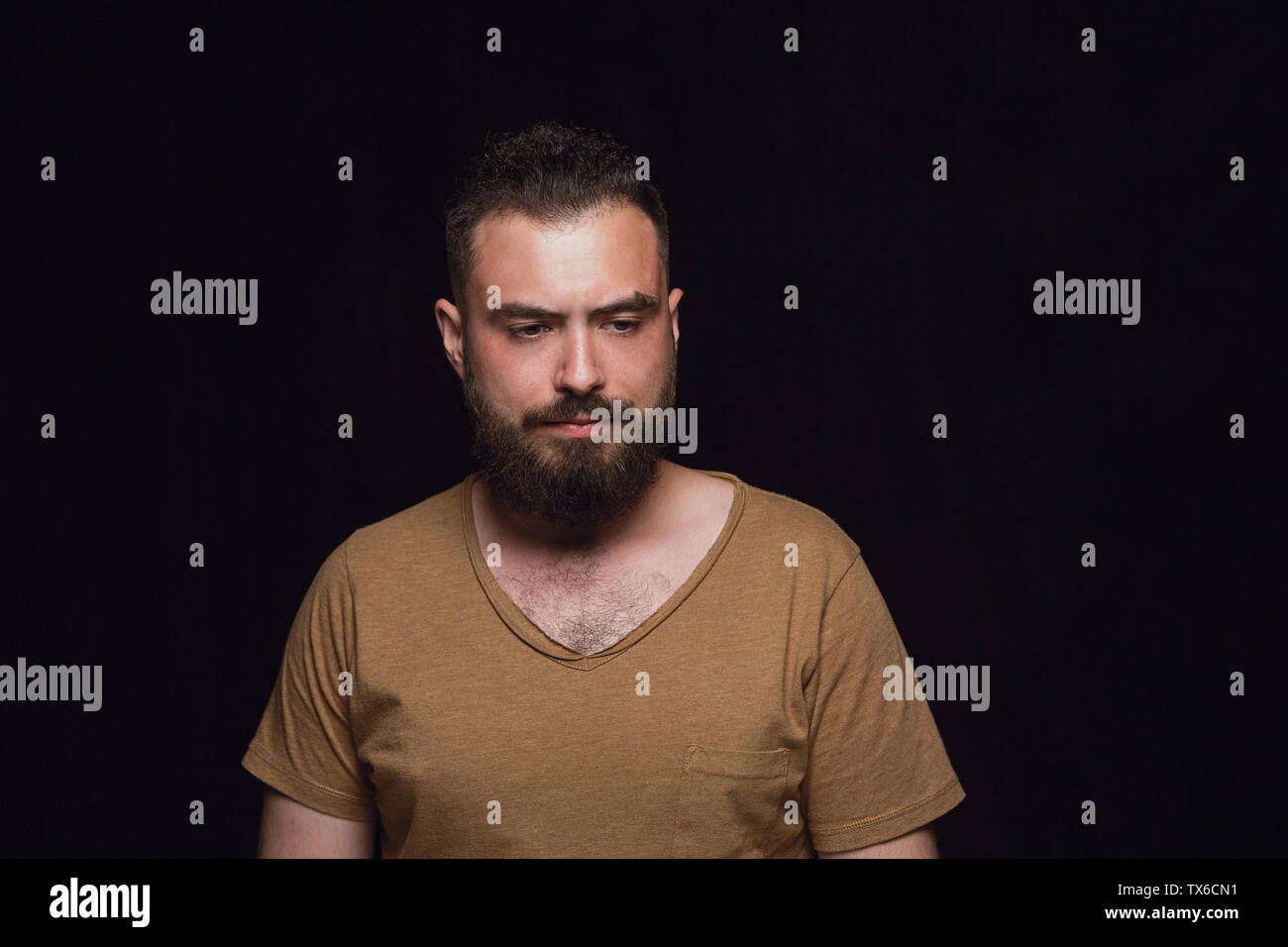 Close up portrait of young caucasian man isolated on black studio ...