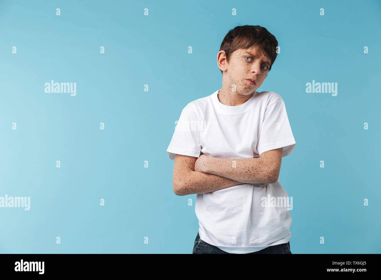 Image of serious disappointed boy 10-12y with freckles wearing white ...