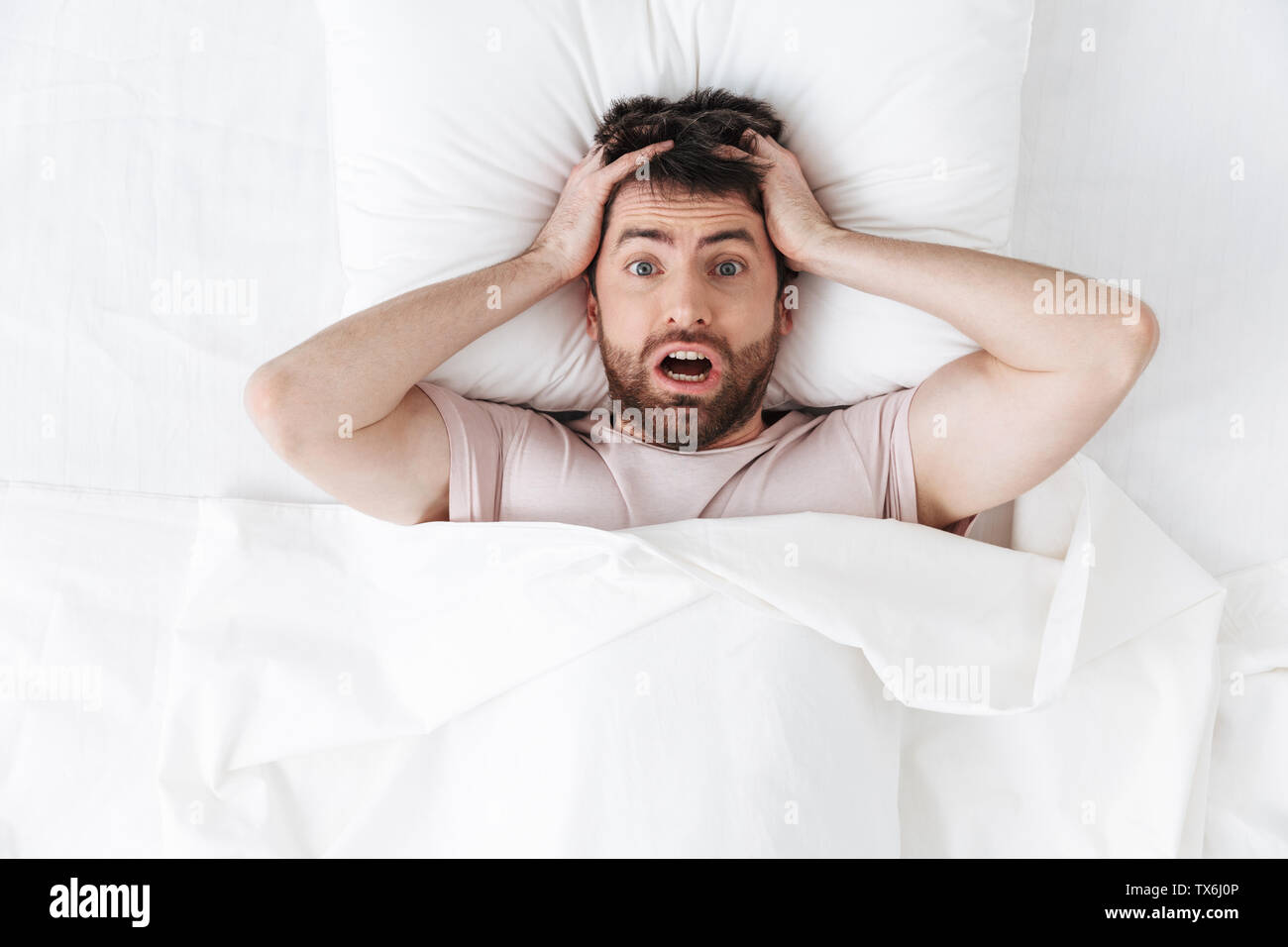 Image of a shocked confused handsome young man in the morning under ...