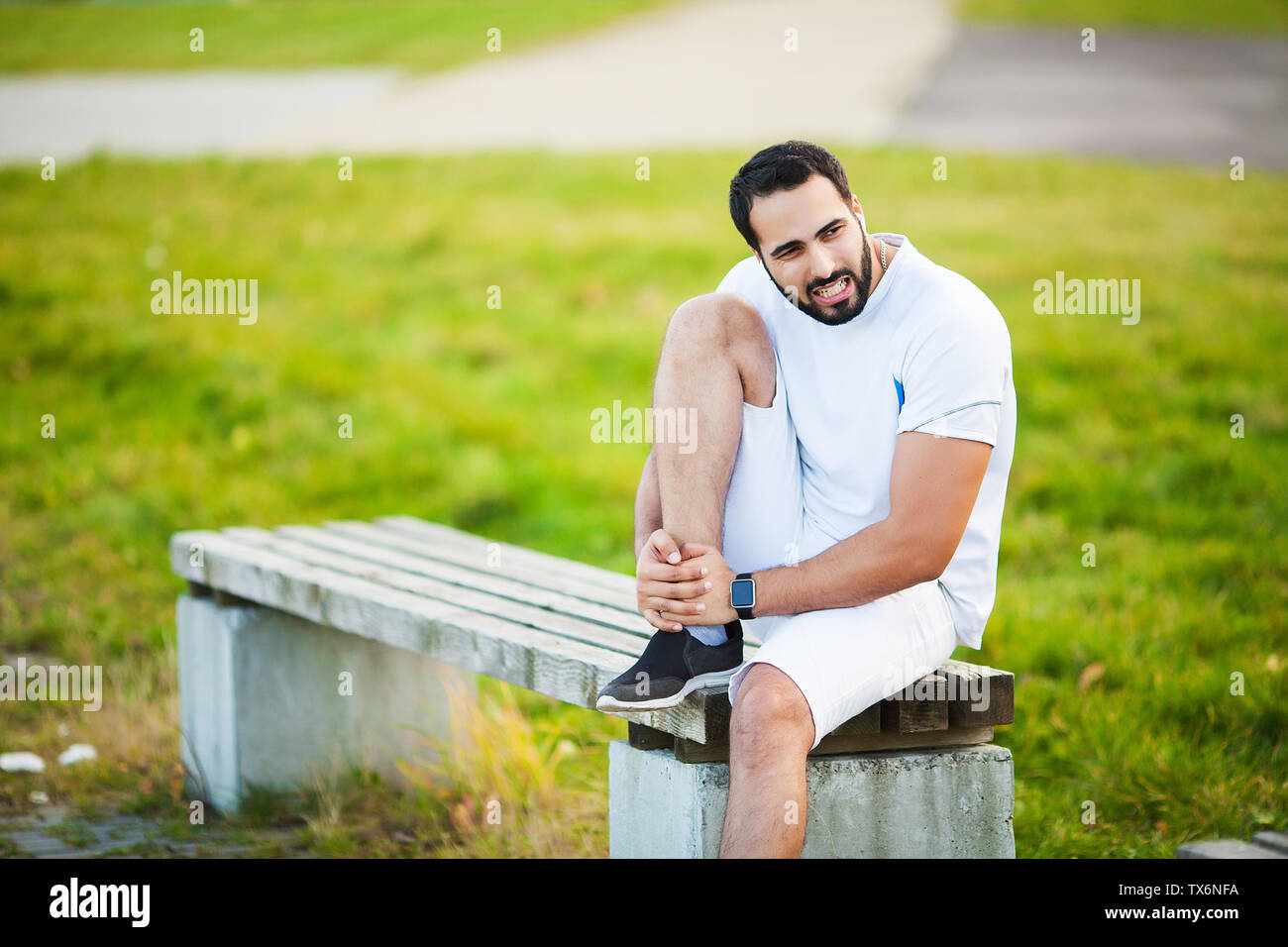 Leg Injury. Male athlete suffering from pain in leg while exercising ...