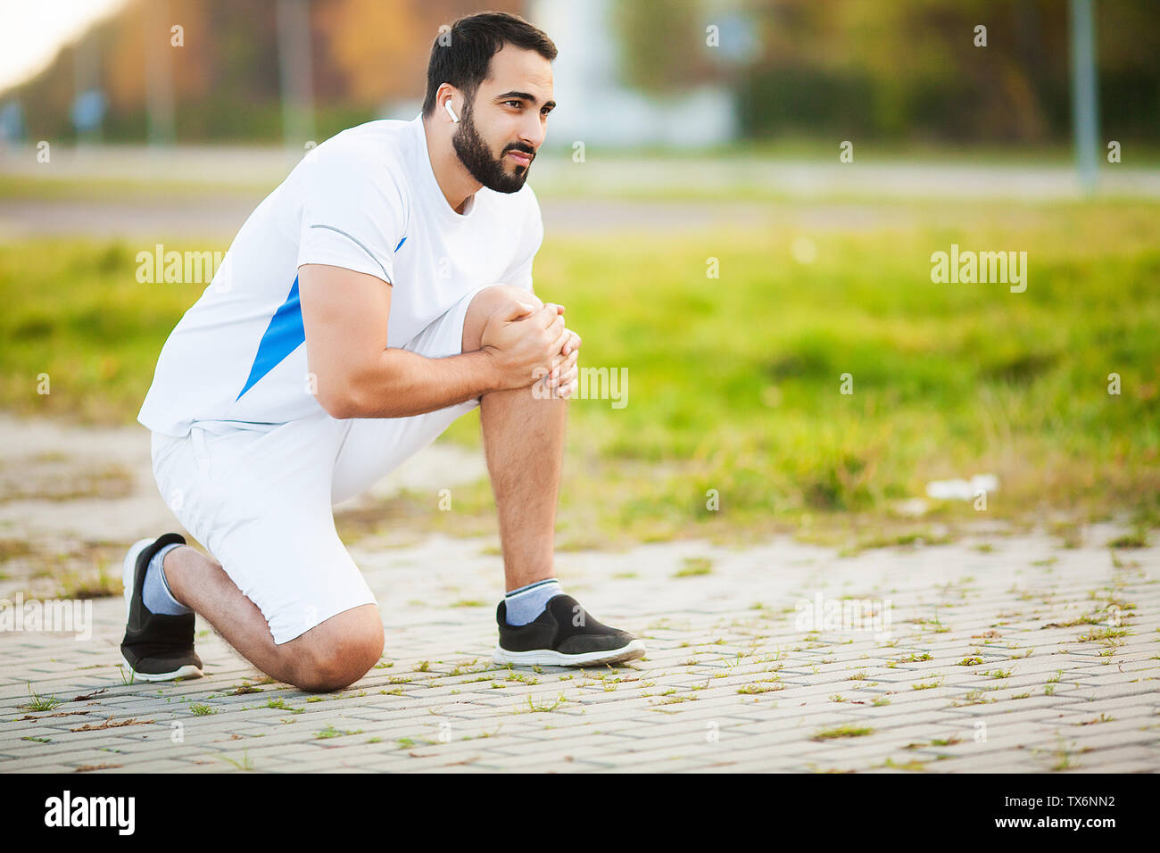 Leg Injury. Male athlete suffering from pain in leg while exercising ...