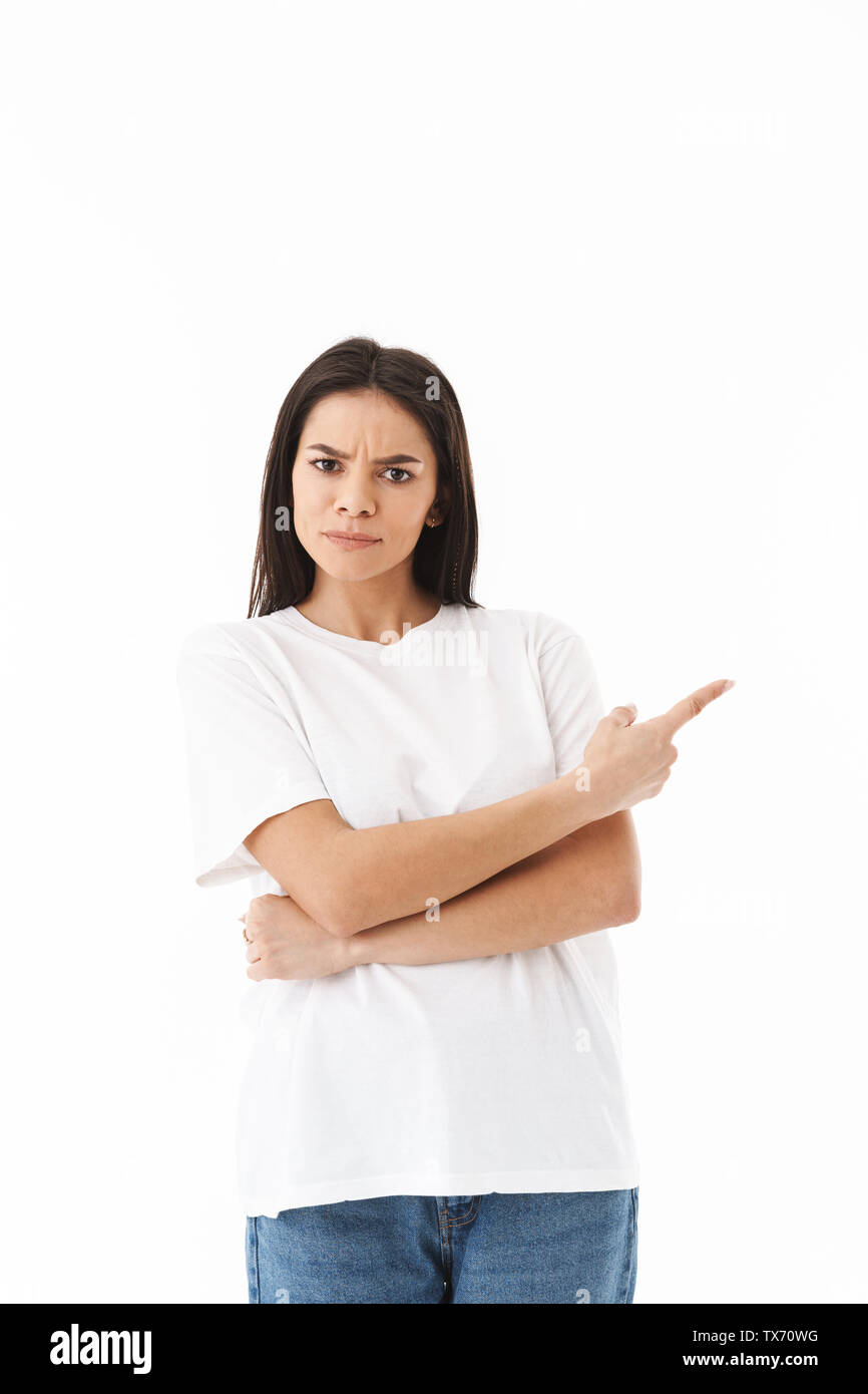 Confused young casual woman standing isolated over white background ...