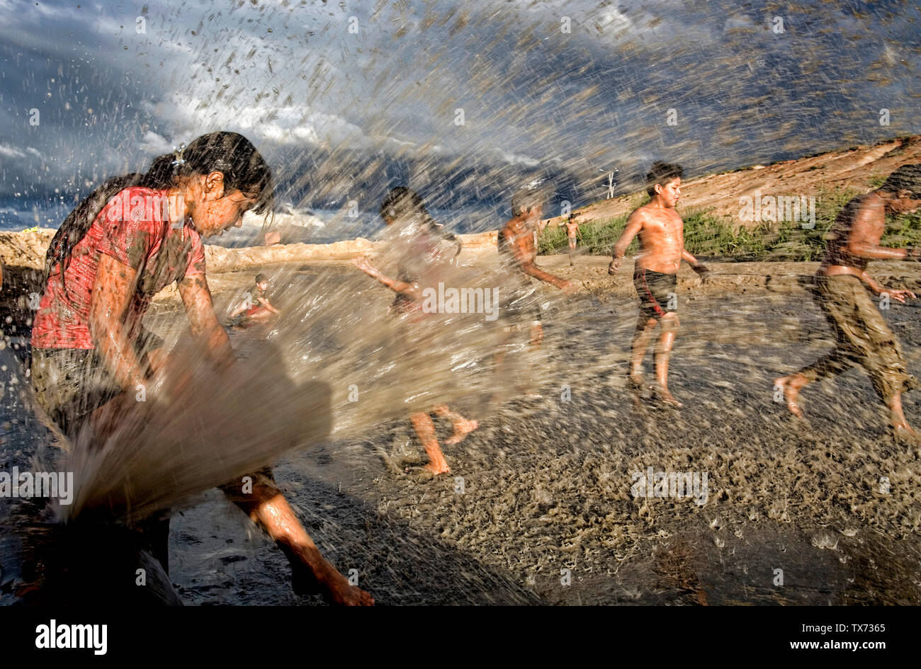 A group of children playing around a broken water pipe used to pull ...