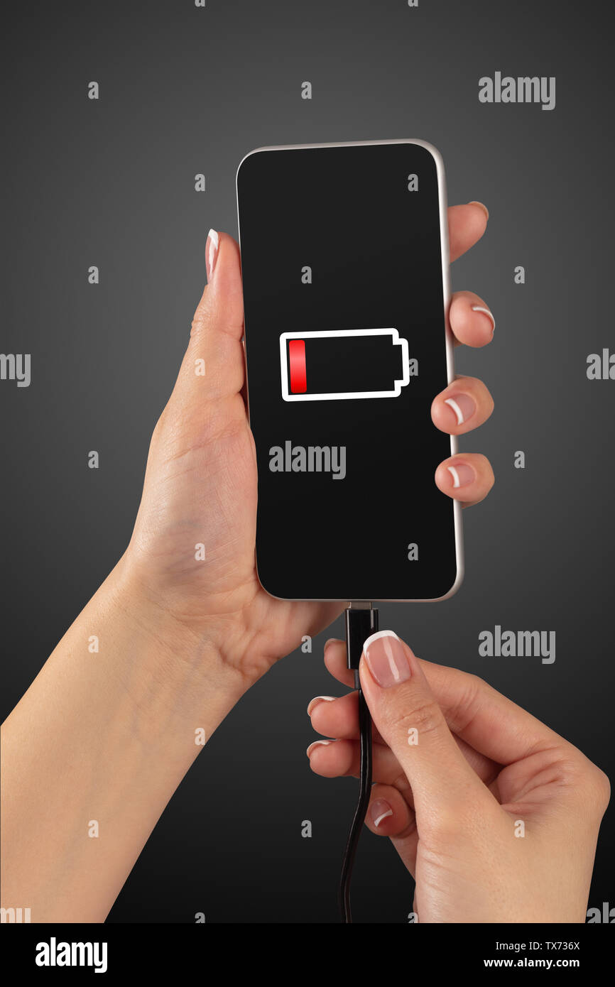 Elegant hand charging cellphone with low battery Stock Photo - Alamy