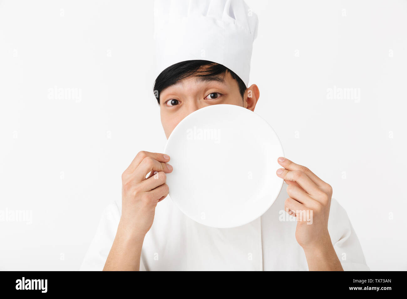 Image of asian funny chief man in white cook uniform smiling at camera ...