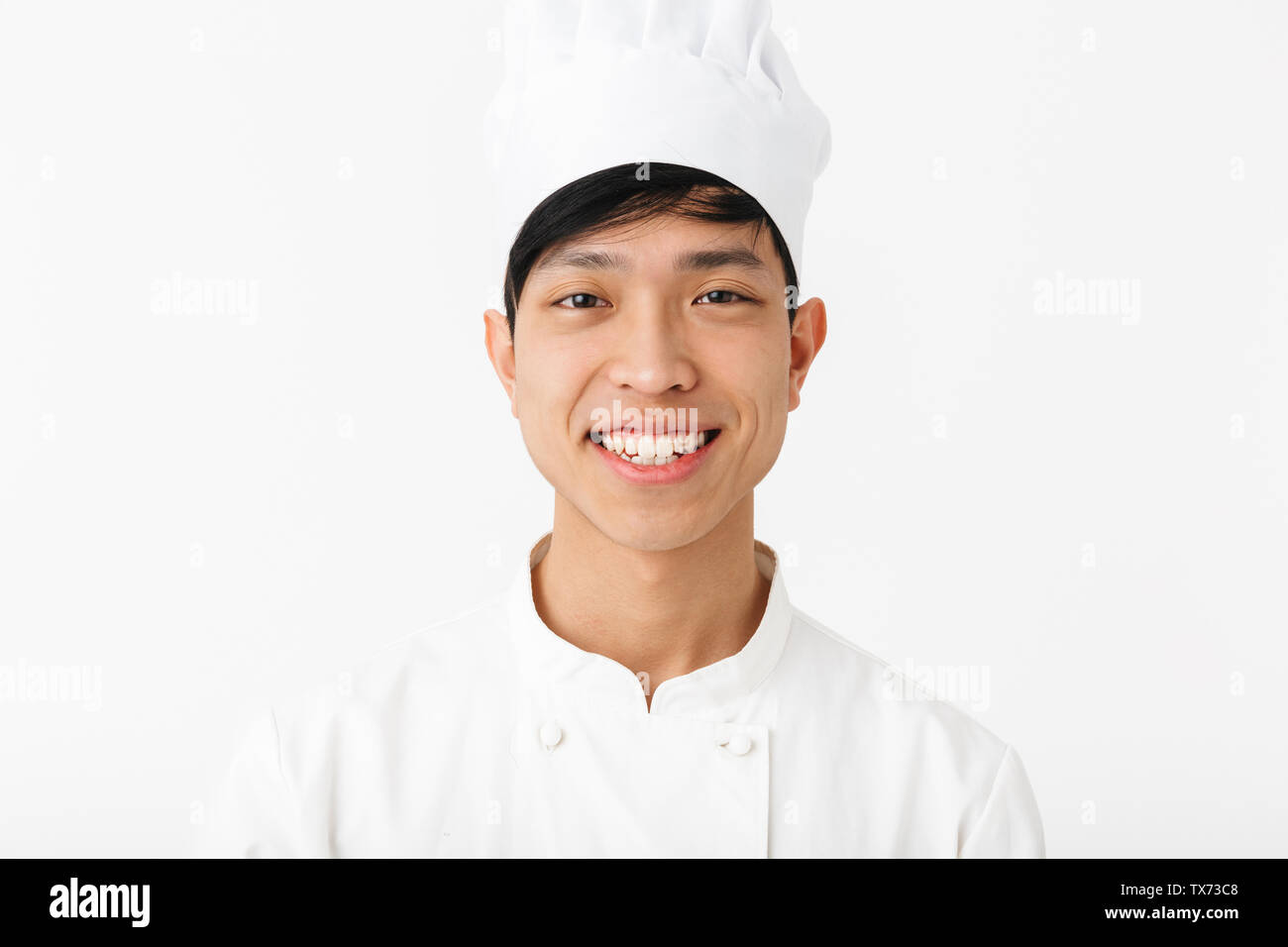 Excited asian chef wearing uniform standing isolated over white ...