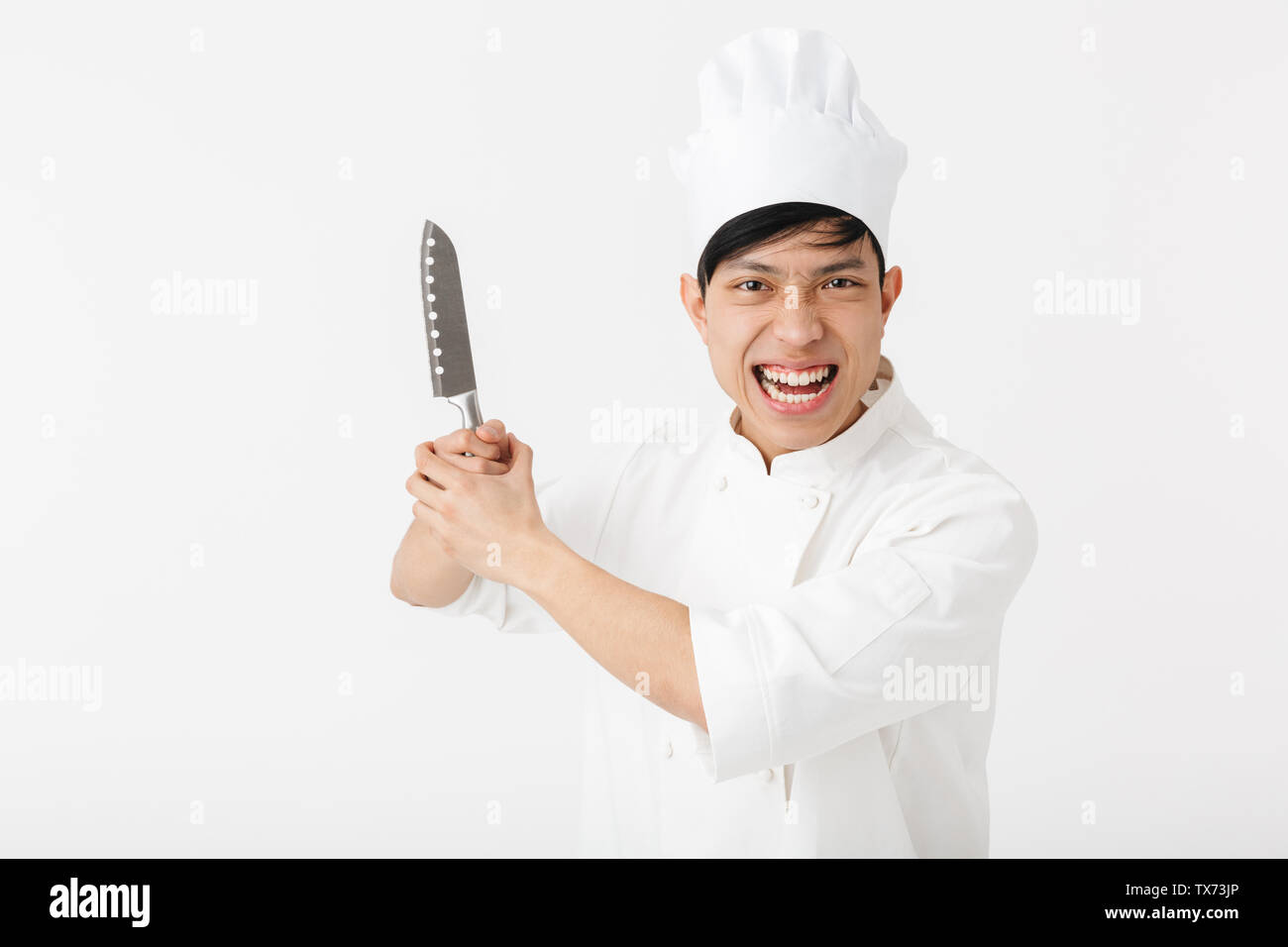 Image of asian joyful chief man in white cook uniform smiling at camera ...