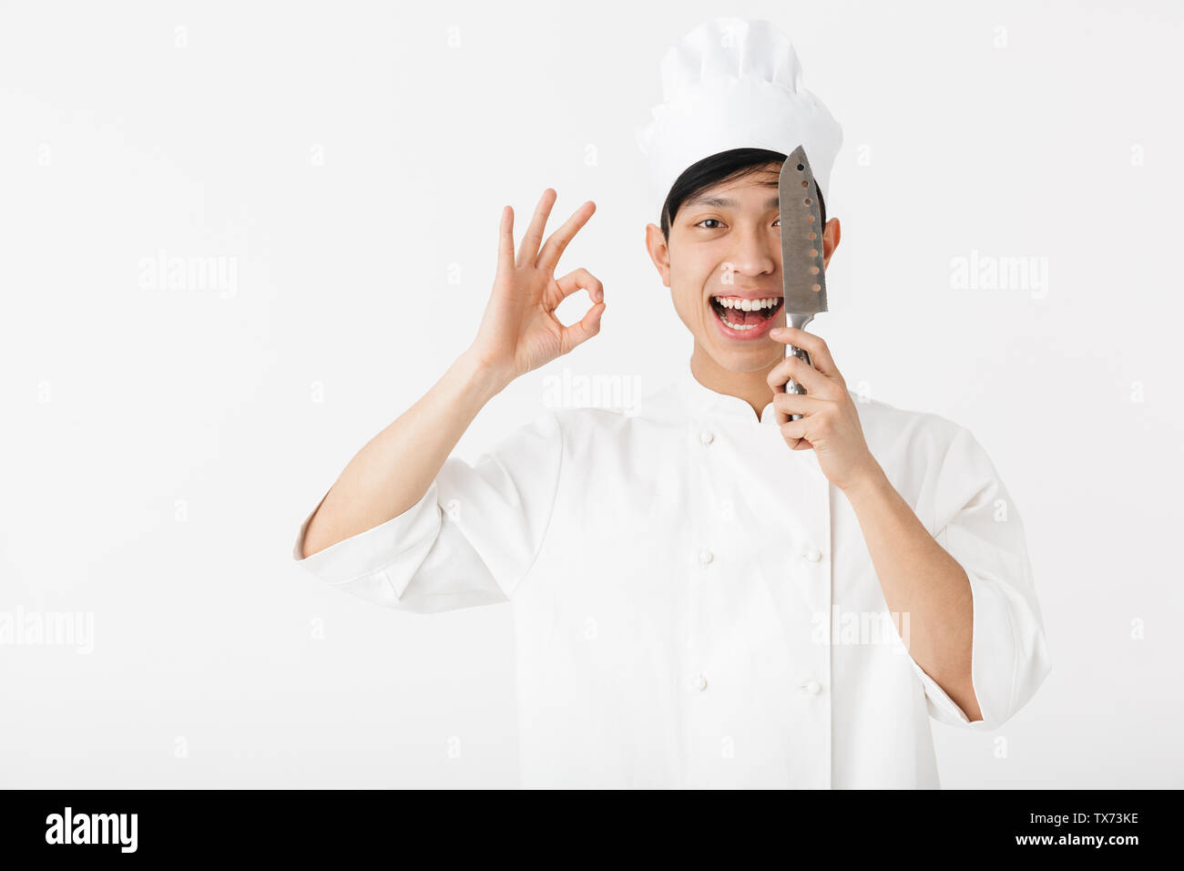 Image of asian happy chief man in white cook uniform smiling at camera ...