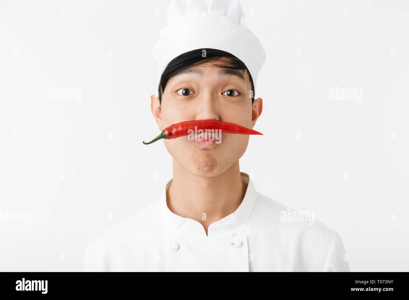 Image of asian positive chief man in white cook uniform with red chili ...