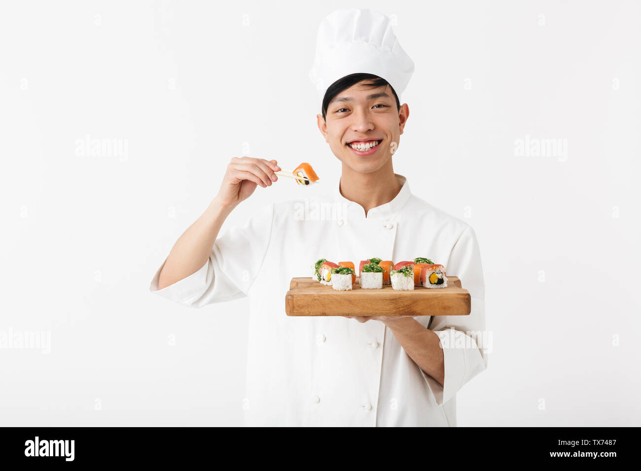 Image of positive chinese chief man in white cook uniform holding plate ...