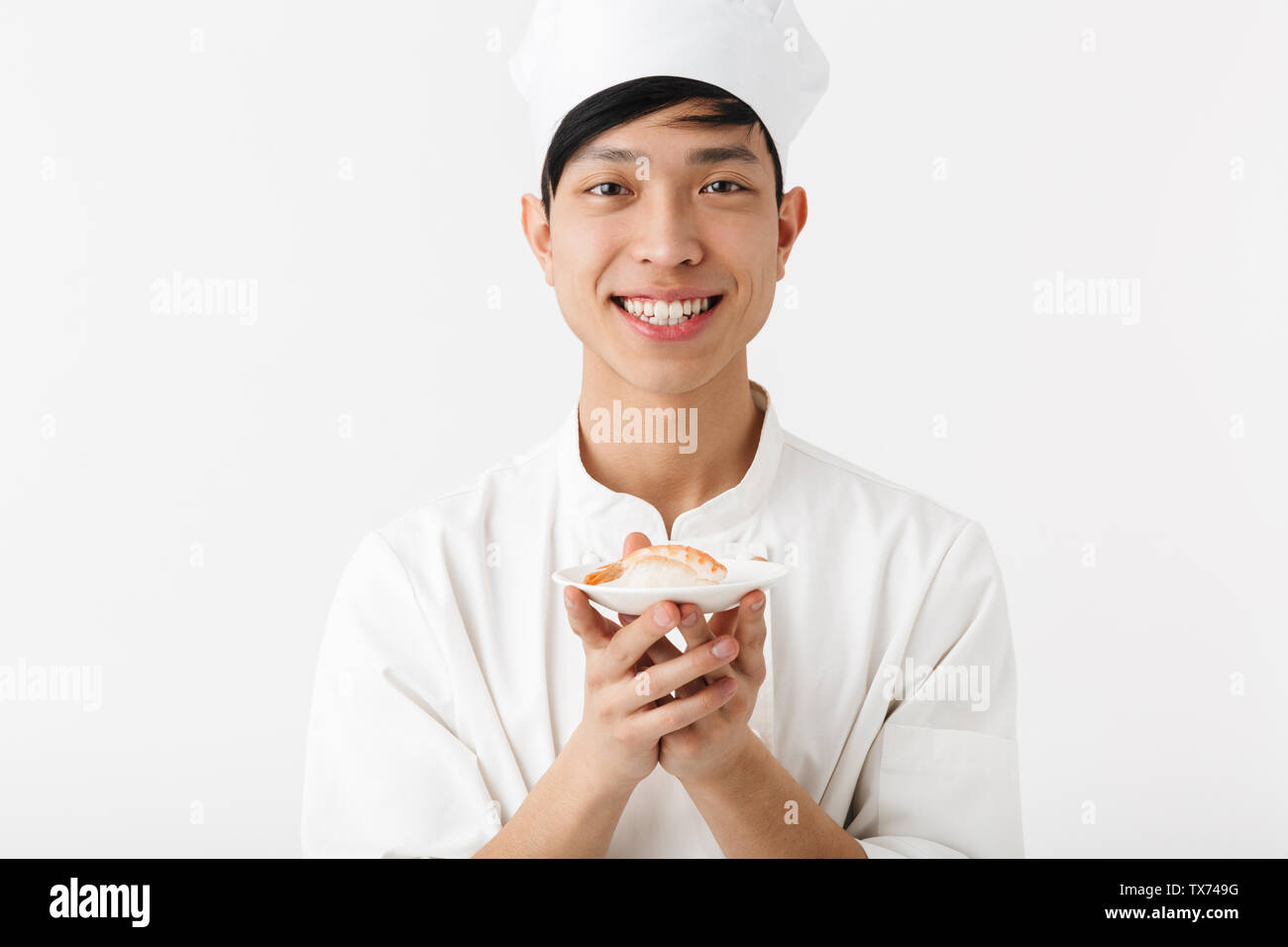 Image of pleased chinese chief man in white cook uniform smiling at ...