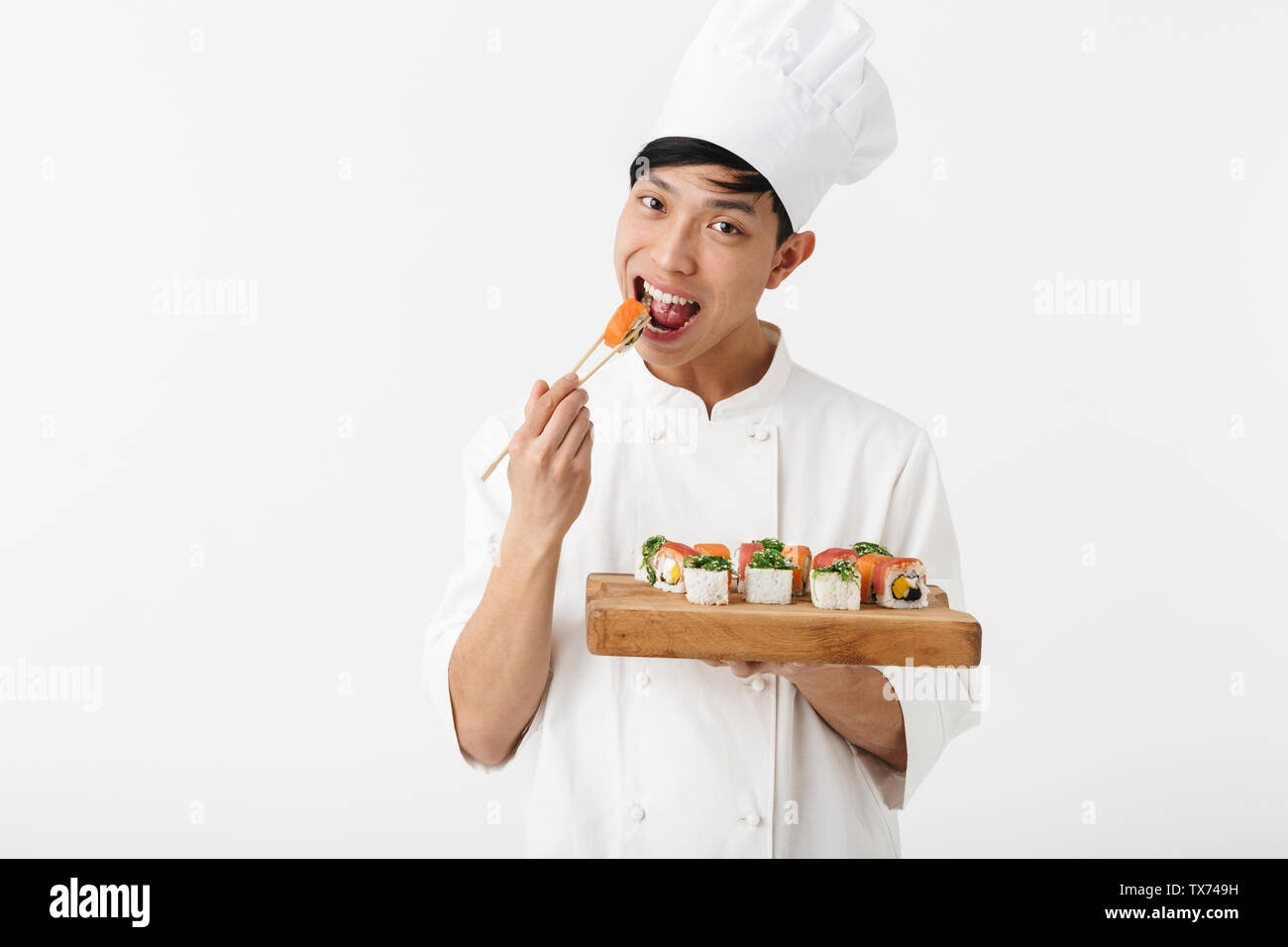 Image of cheerful chinese chief man in white cook uniform holding plate ...