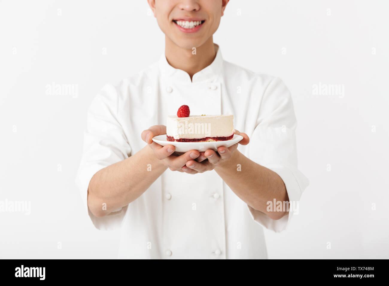 Image of excited chinese chief man in white cook uniform smiling at ...