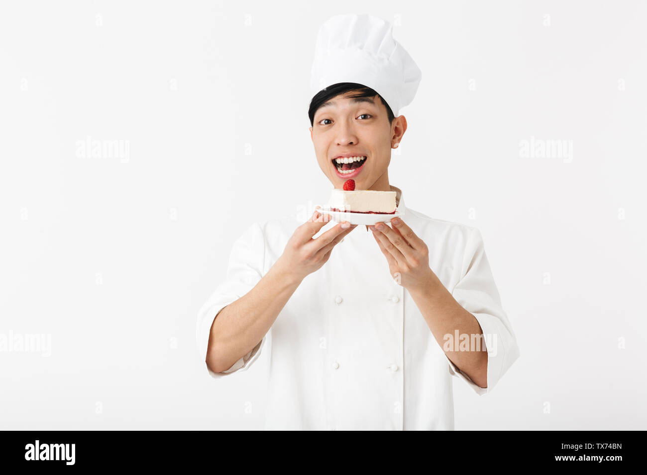 Image of young chinese chief man in white cook uniform smiling at ...