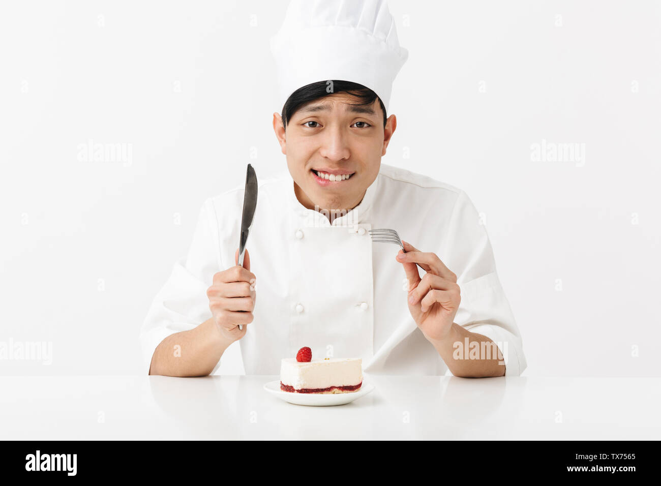 Image of cheery asian chief man in white cook uniform smiling at camera ...