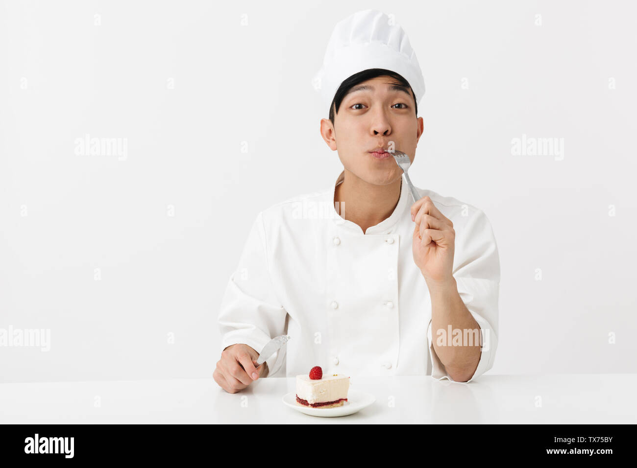 Image of cheery asian chief man in white cook uniform smiling at camera ...