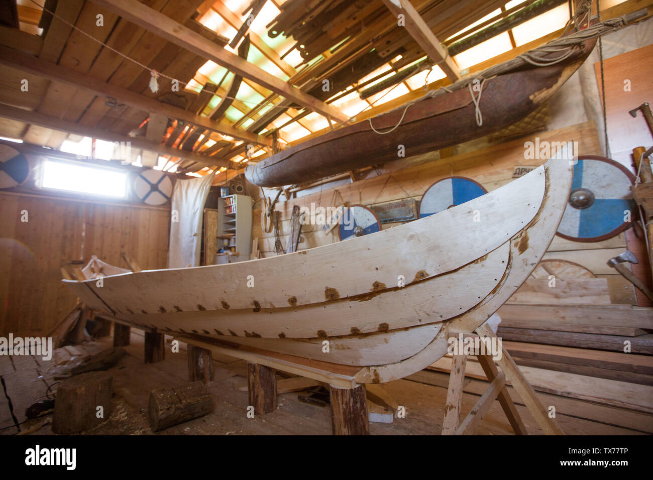Handmade wooden boat in the barn , work tools and reenactor shields on ...