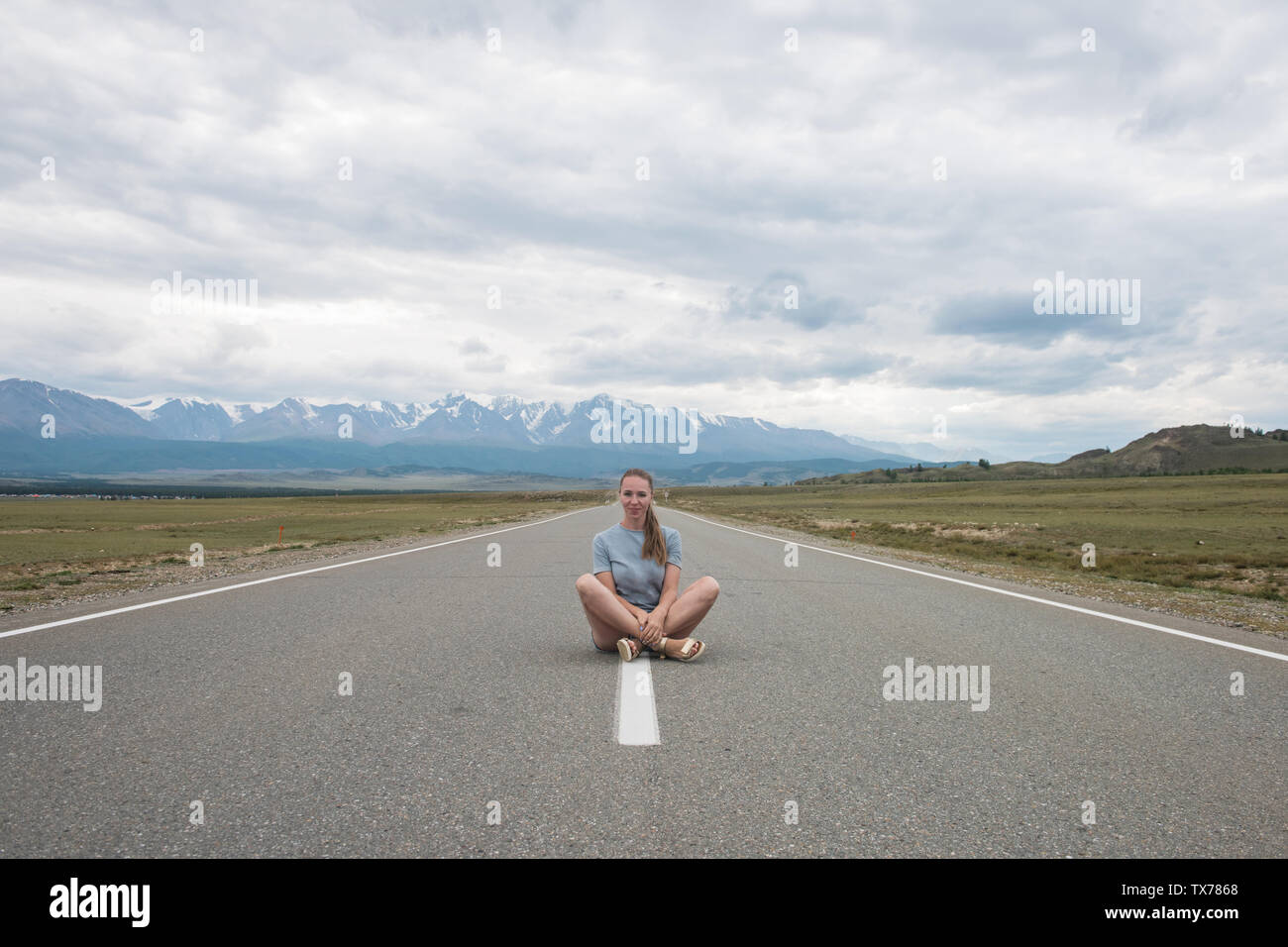 Woman sitting on the road Stock Photo - Alamy