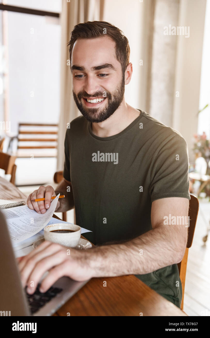Photo of successful mature man 30s in casual clothing writing down ...