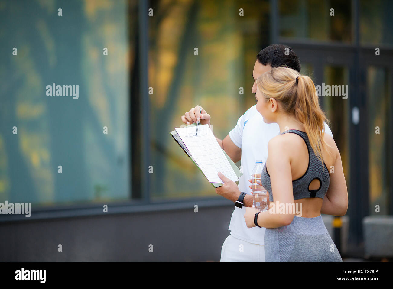 Fitness. Personal Trainer Takes Notes While Woman Exercising Outdoor ...