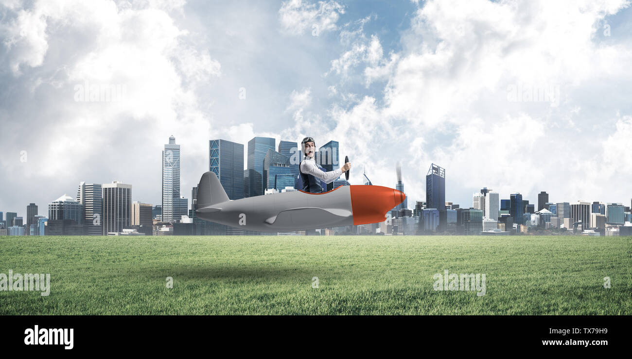 Happy aviator driving small propeller plane. Modern business center ...