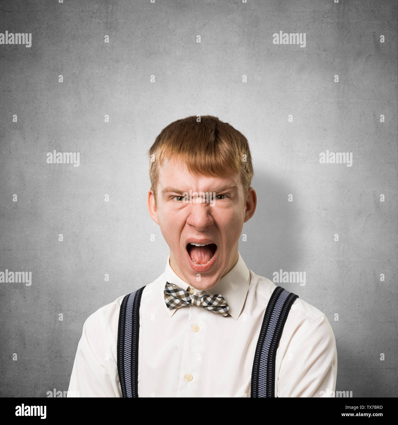 Frenzied teenager screaming with anger. Emotional redhead boy has ...