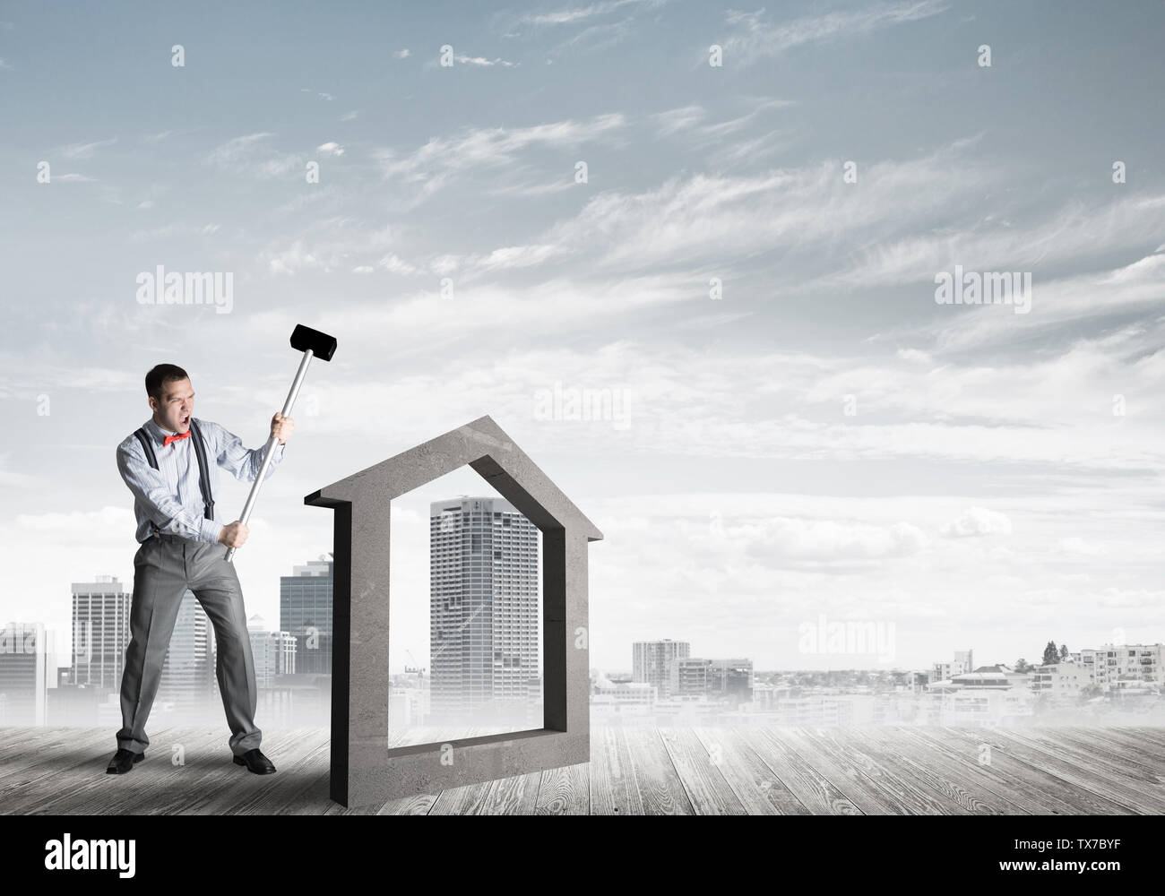 Determined businessman going to break with hammer house concrete figure ...