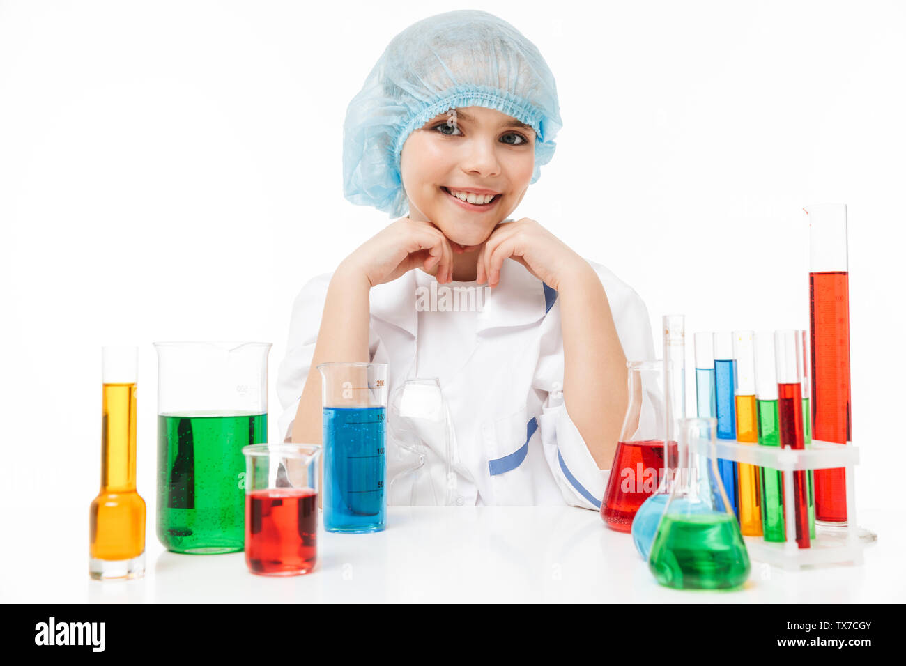 Portrait of cute little girl in white laboratory coat making chemical ...