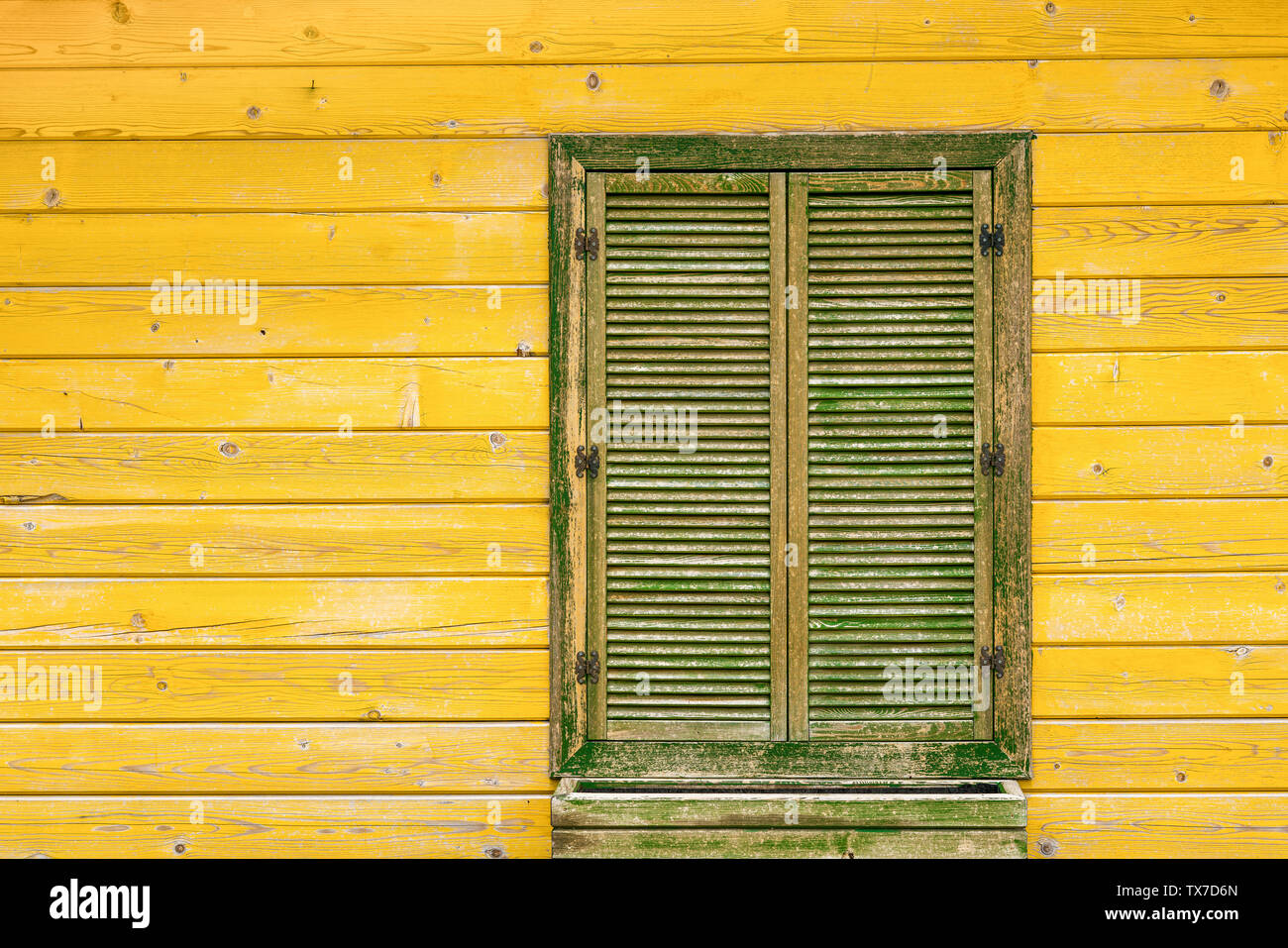 Old yellow wooden wall with green window.House decoration Stock Photo ...