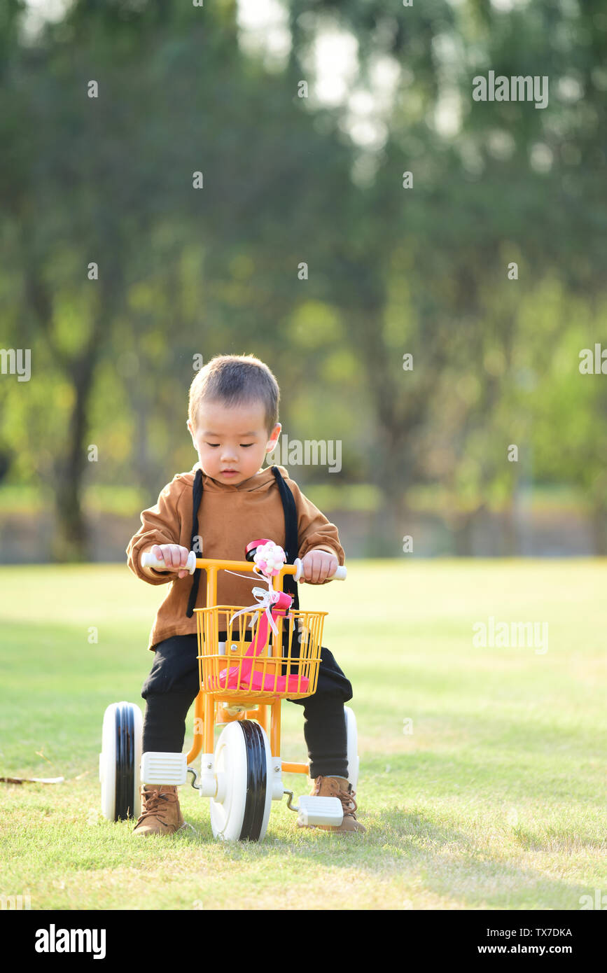 Little boy riding a tricycle Stock Photo - Alamy