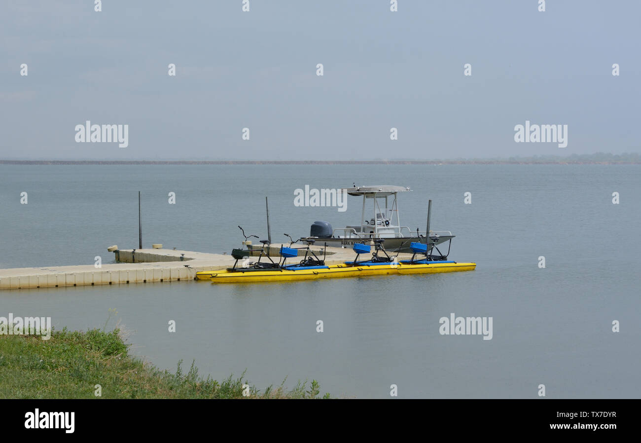 Park Ranger boat and pedal boats empty at the dock during a rain storm ...