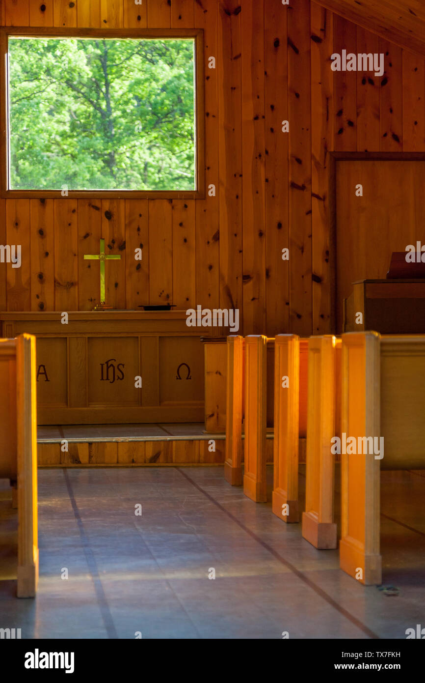 The interior of a small country chapel with a gold cross and soft ...