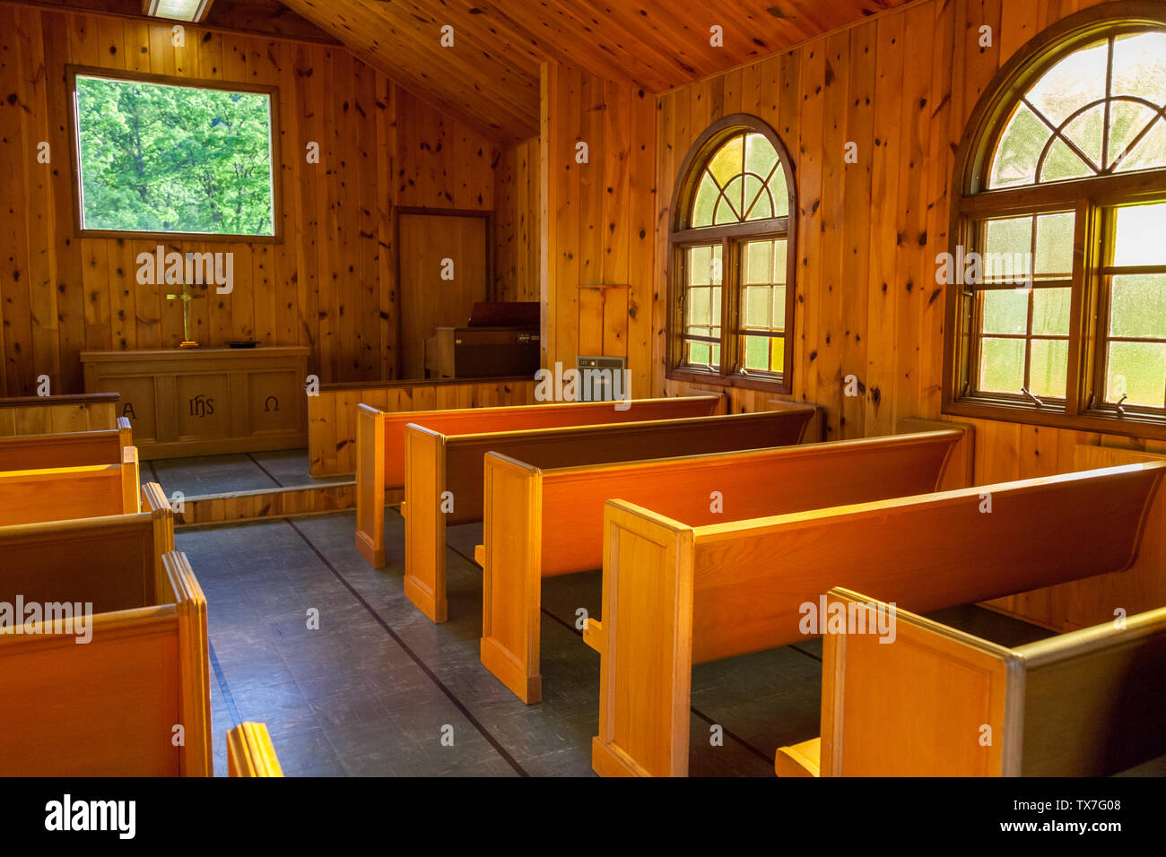 The interior of a small country chapel with a gold cross and soft ...