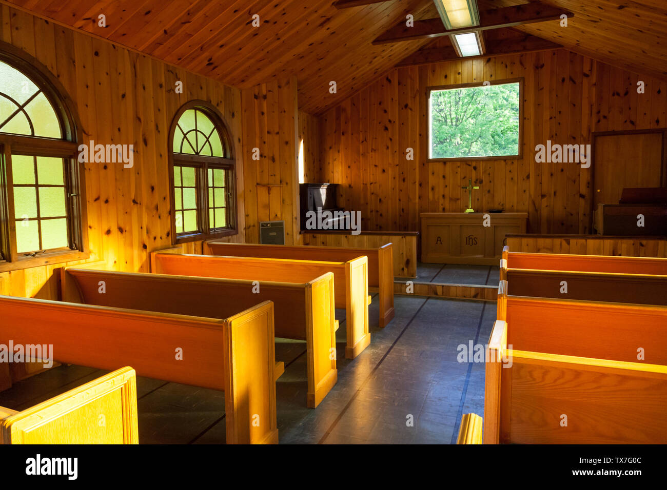 The interior of a small country chapel with a gold cross and soft ...