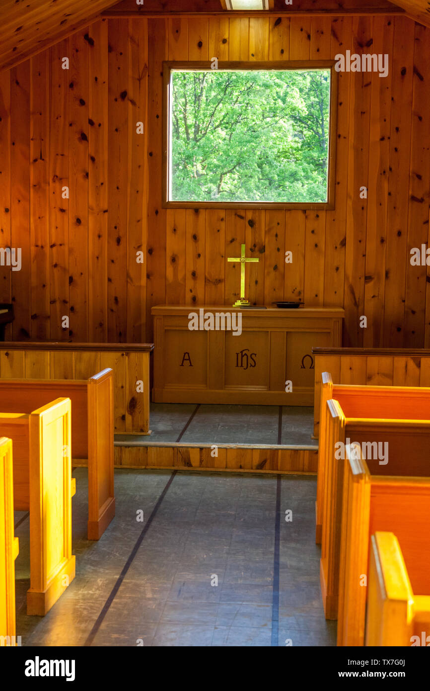 The interior of a small country chapel with a gold cross and soft ...