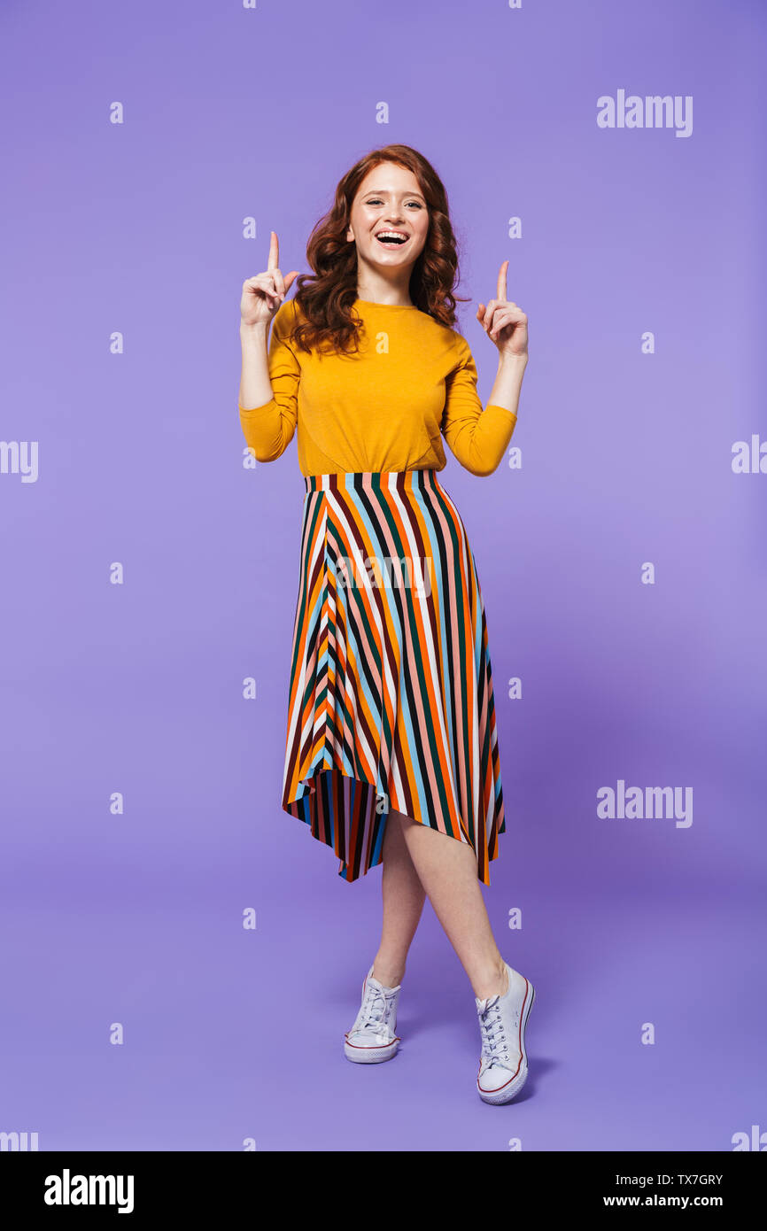 Full length portrait of a pretty young redheaded woman standing ...