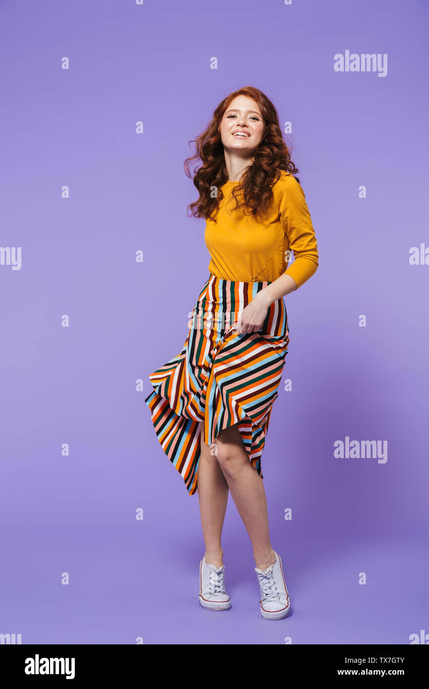 Full length portrait of a pretty young redheaded woman standing ...