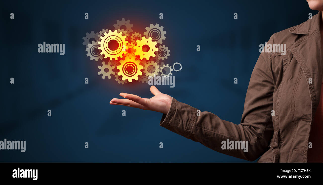 Hand holding gears in his hand Stock Photo - Alamy