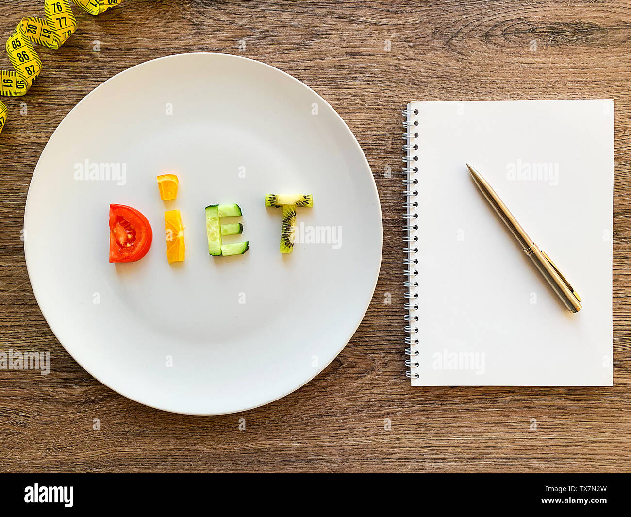 Word DIET made of sliced vegetables in white plate and diet plan on ...