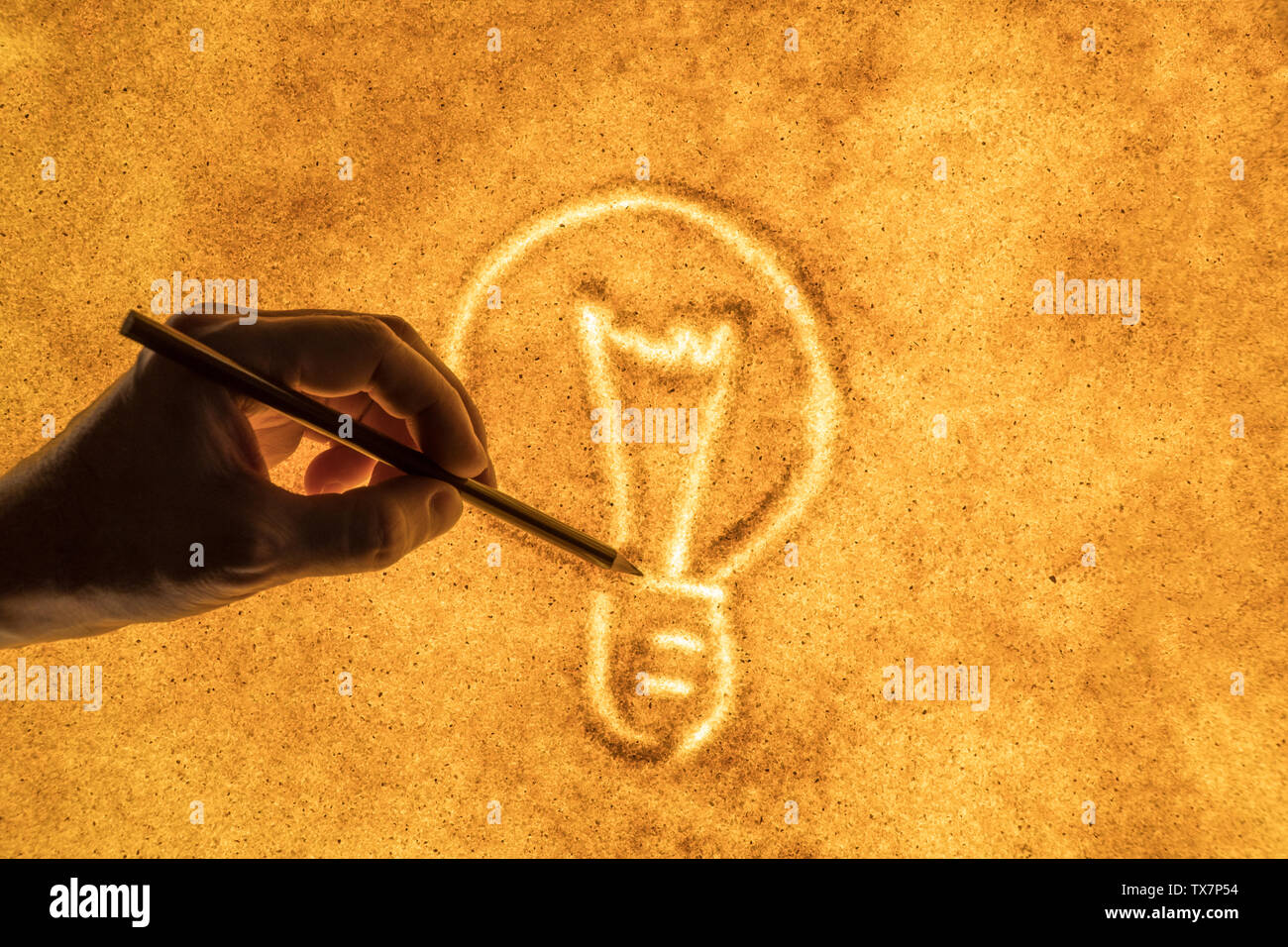 the hands of men draw in the sand a symbol of the bulb. the concept of ...