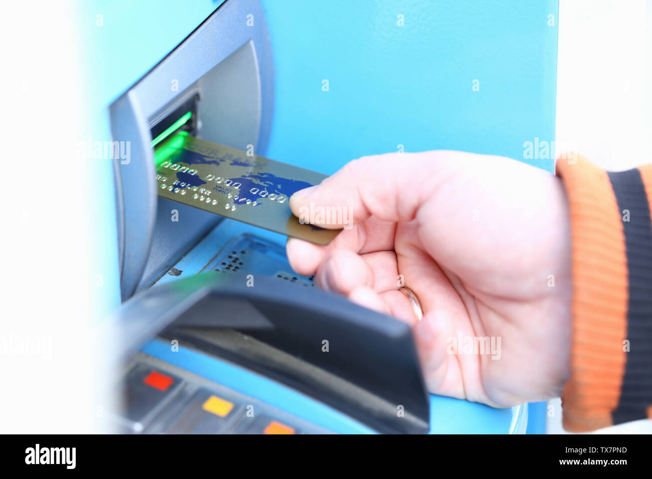 Male hand hold golden credit card aganist ATM background Stock Photo ...