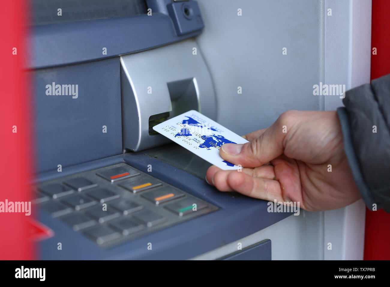 Male hand hold white credit card aganist ATM background Stock Photo - Alamy